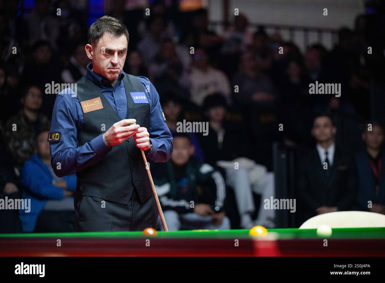 Macao. 28th Dec, 2024. Ronnie O'Sullivan of England chalks his cue ...