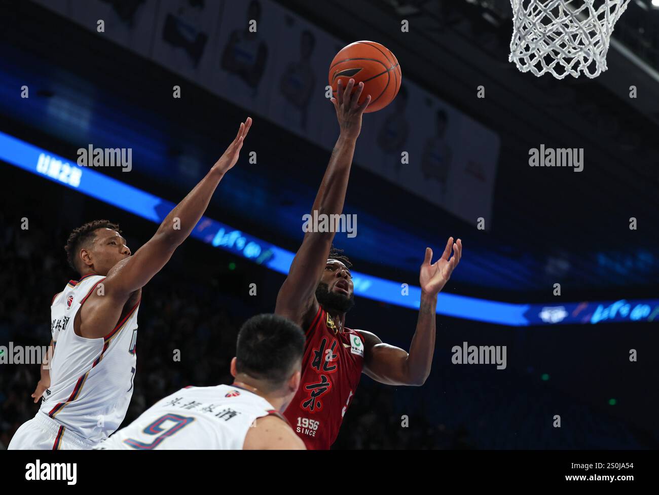 Beijing, China. 28th Dec, 2024. Eugene German (R) of Beijing Ducks goes ...