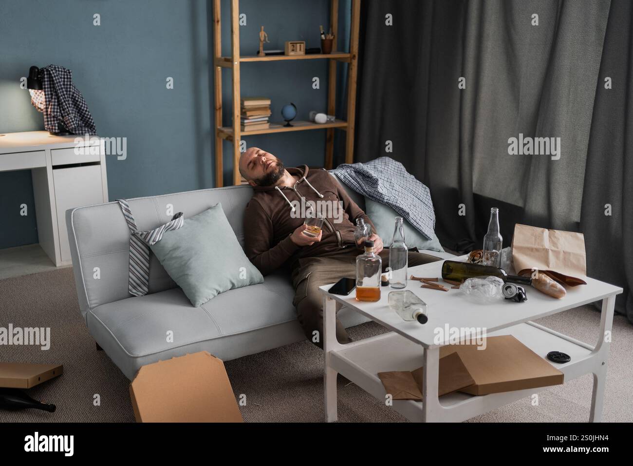 drunk man fell asleep on sofa at home with bottle and glass of alcohol ...