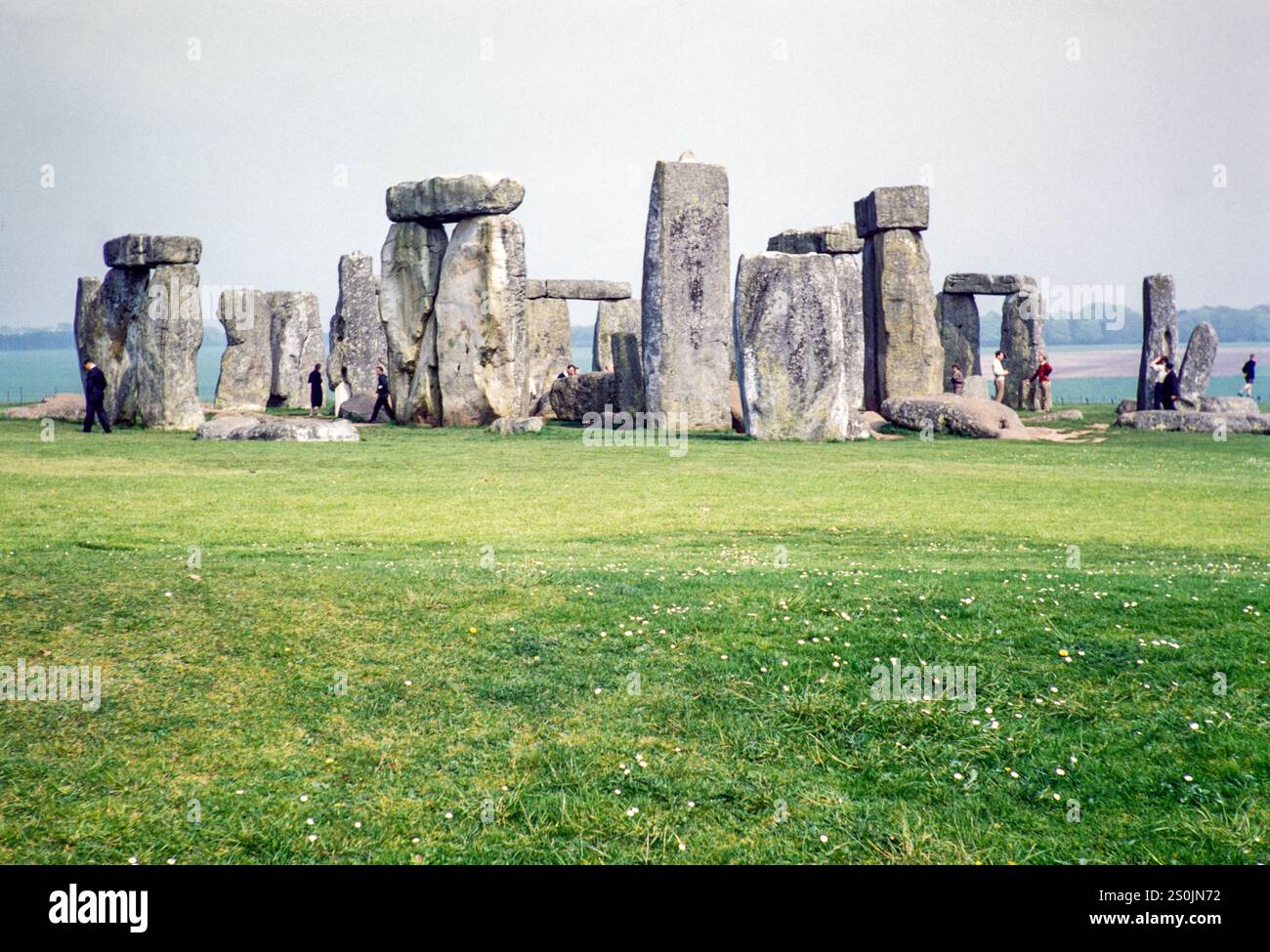 People exploring the standing stones at Stonehenge neolithic site ...