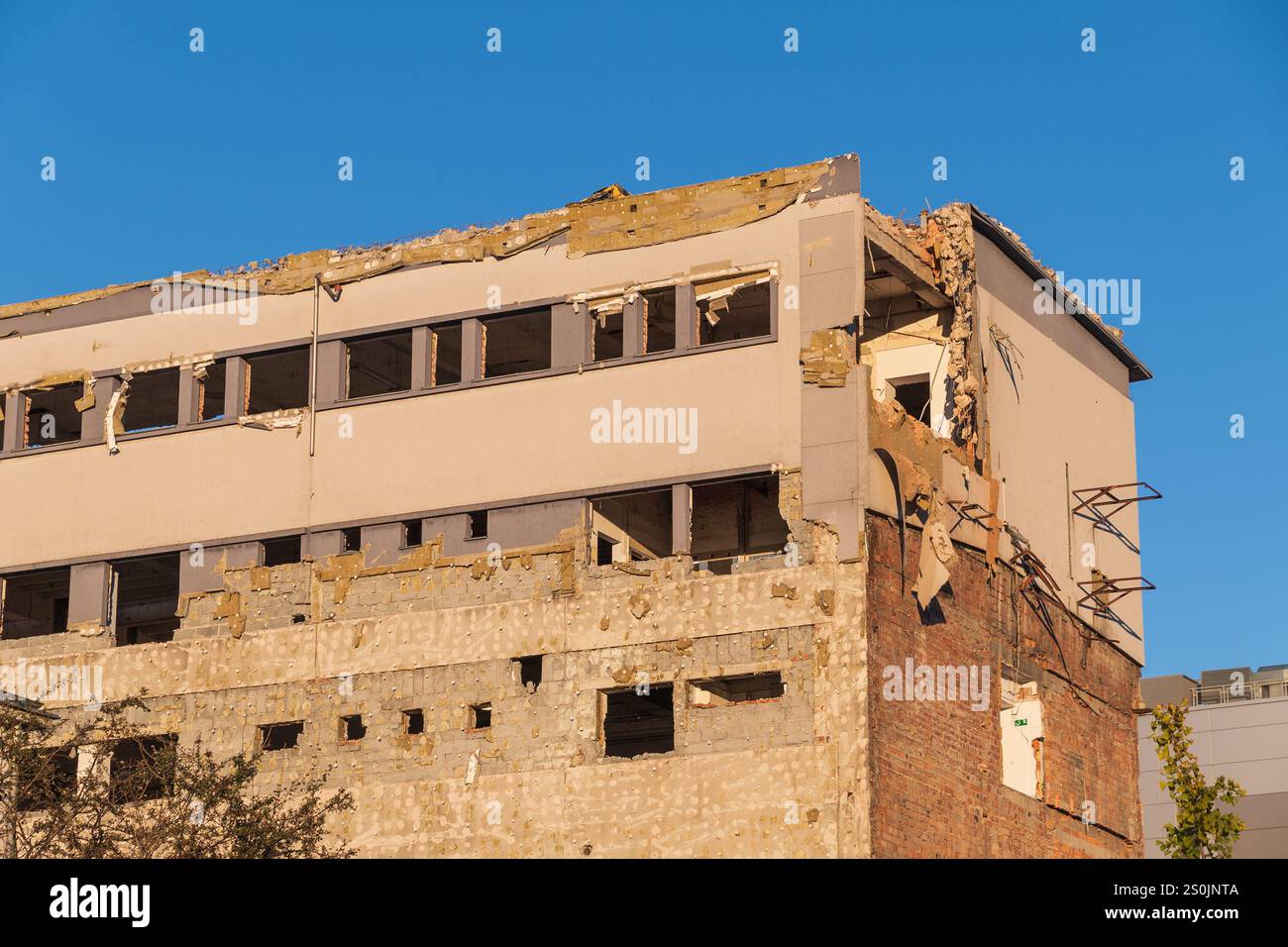 Partially demolished building with exposed bricks and concrete against ...