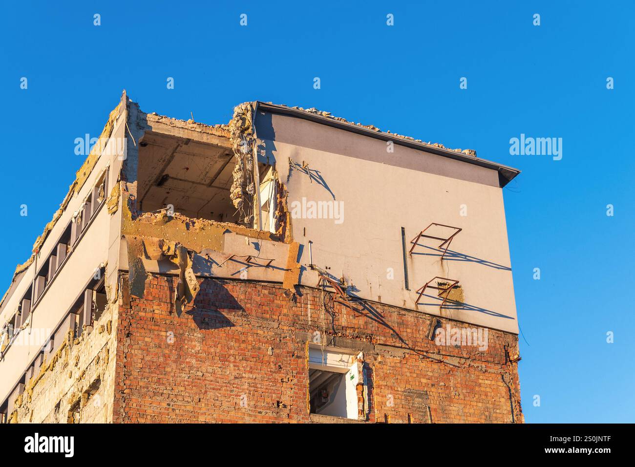 Partially demolished building with exposed bricks and concrete against ...