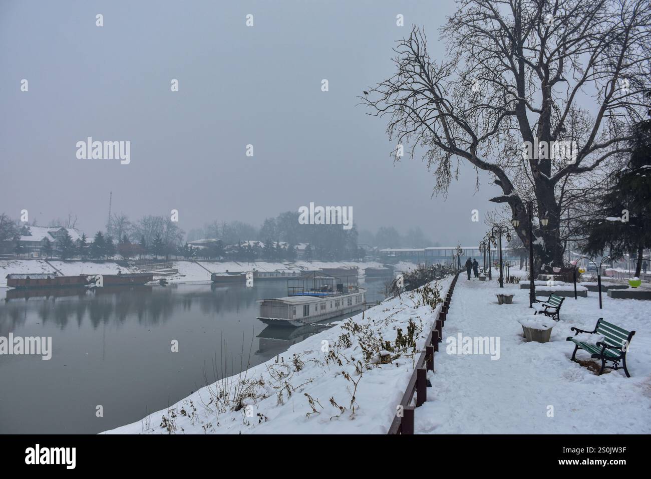 Residents walk along the snow covered street after seasons first ...