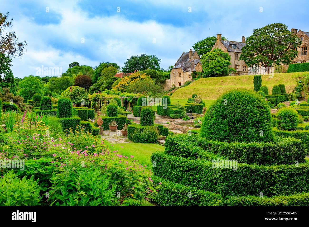 A variety of topiary shaped hedges and herbaceous borders in the ...