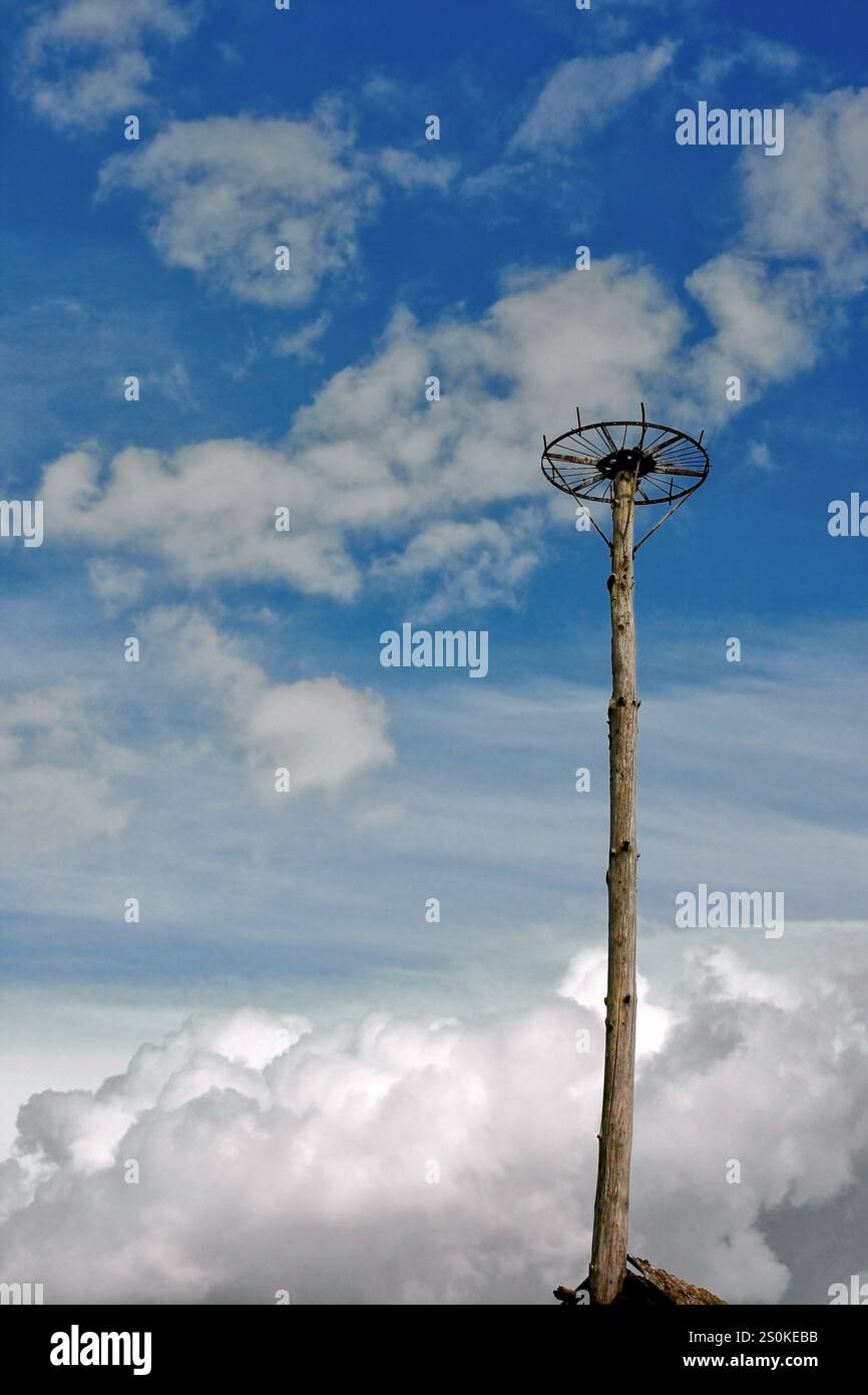 A wooden pole topped with a circular metal structure under a vibrant ...