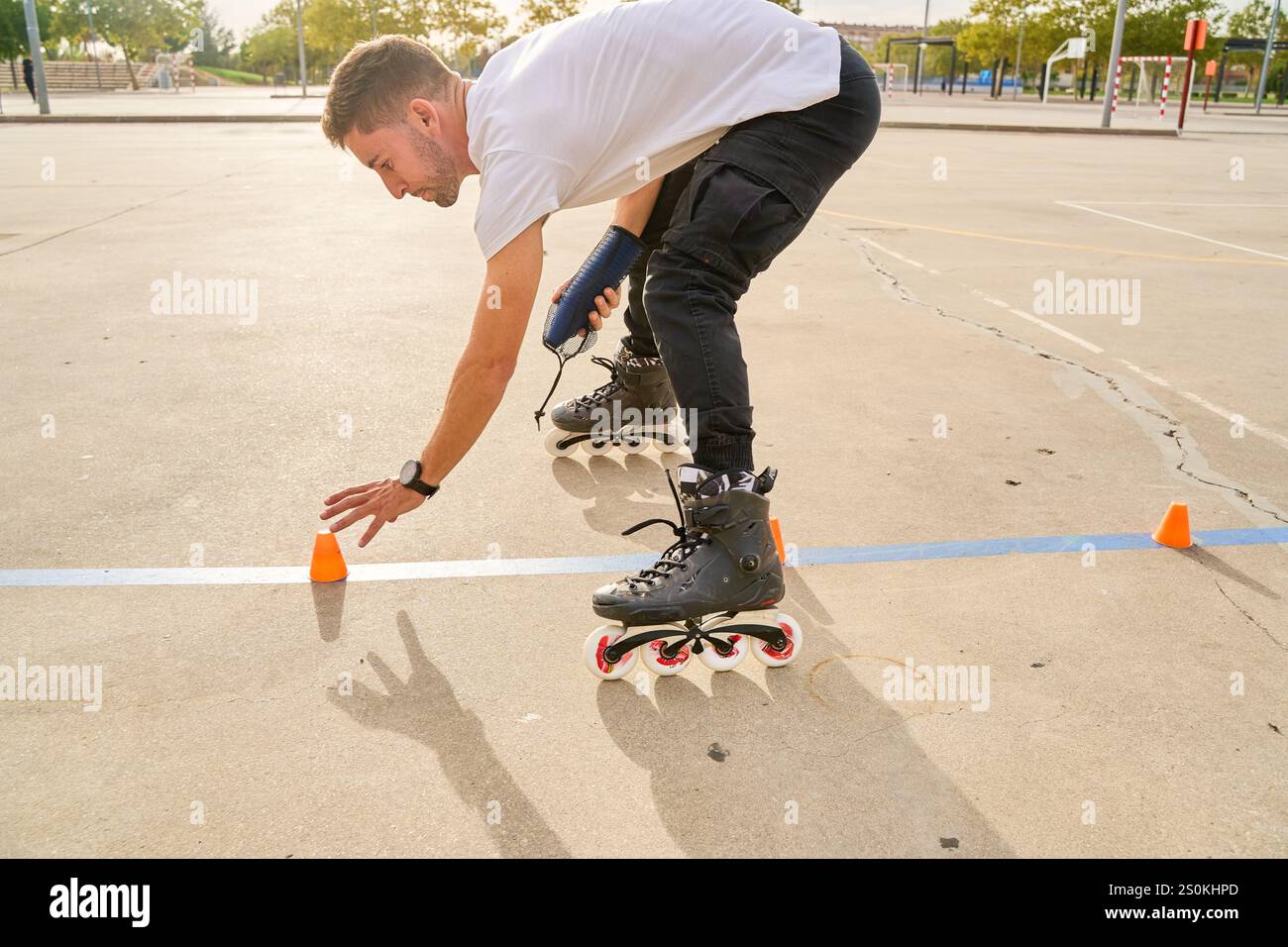 Man adjusting cones while rollerblading in an outdoor park Stock Photo ...