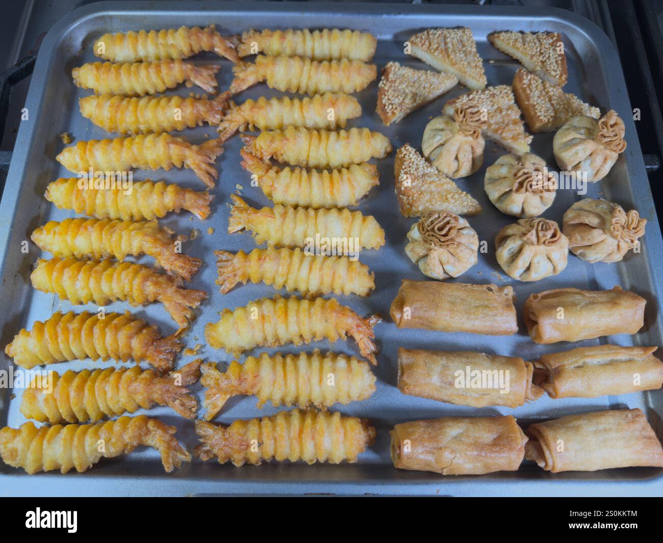 Crispy baked, battered snacks on an oven tray, consisting of tempura ...