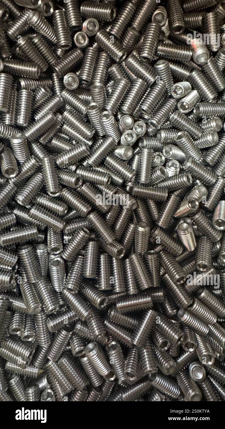 A close-up shot depicts a large quantity of metallic, cylindrical set ...