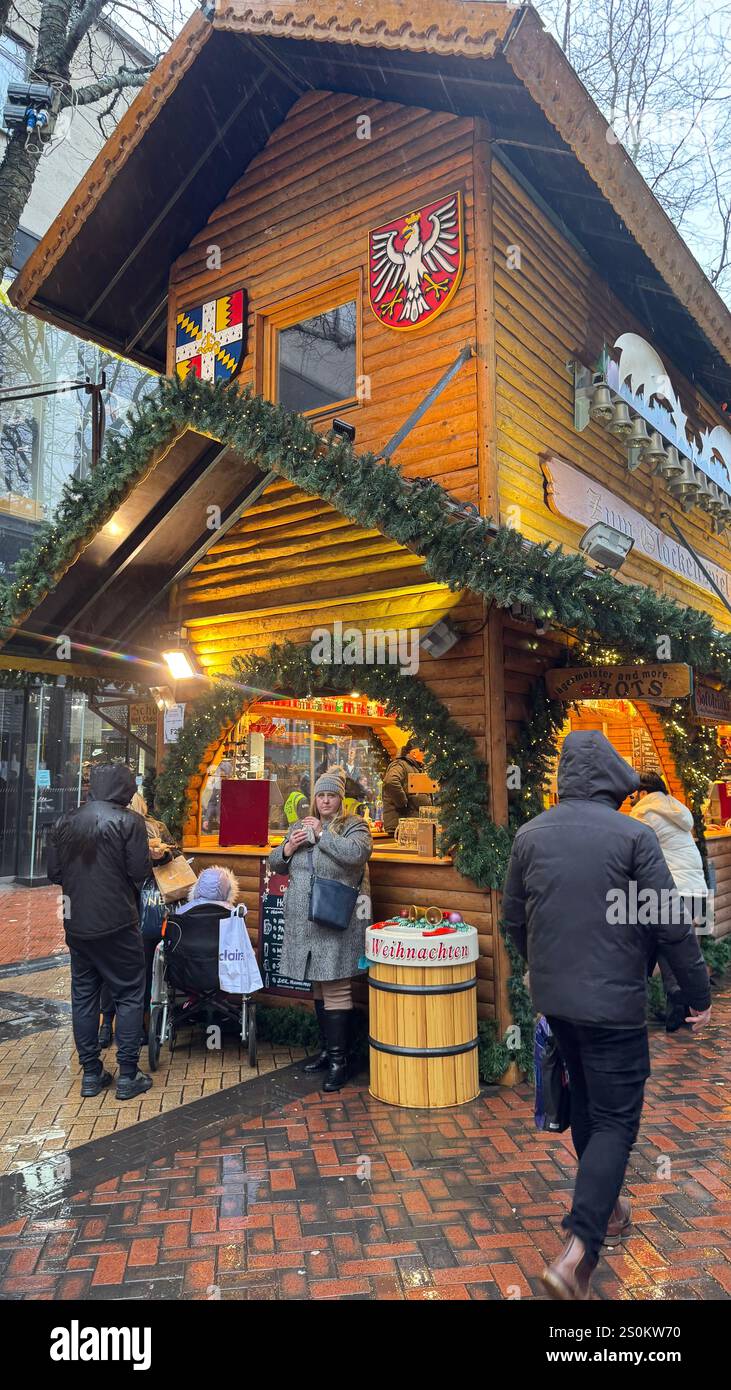 Wooden Christmas market stall with coats of arms, evergreen garland ...