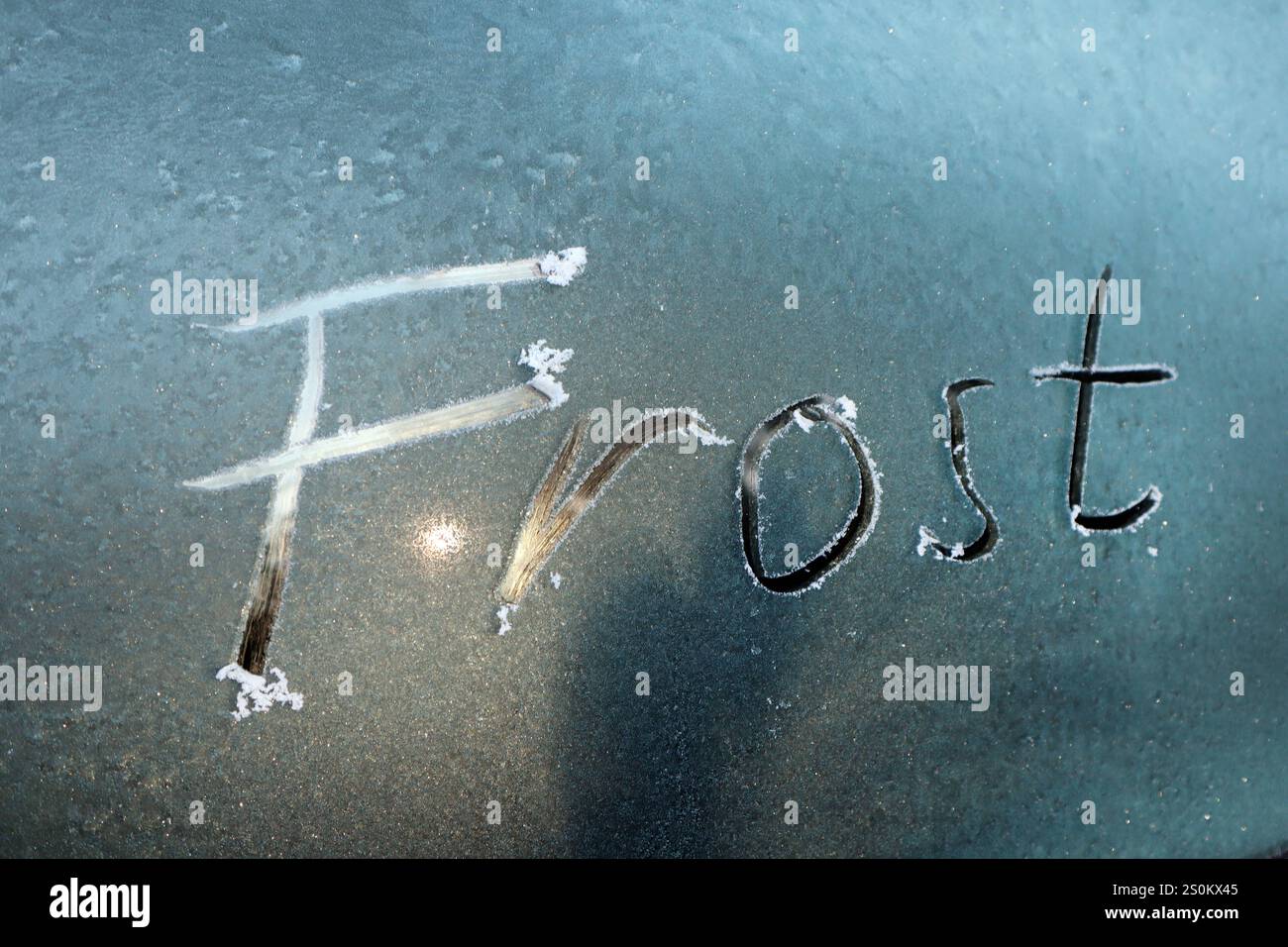 Autoglas und Winterzeit Jemand hat das Wort Frost in das Eis auf dem ...