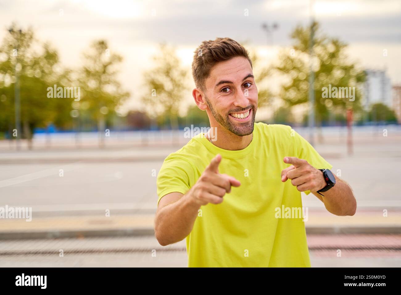 Smiling skating instructor pointing at the camera Stock Photo - Alamy