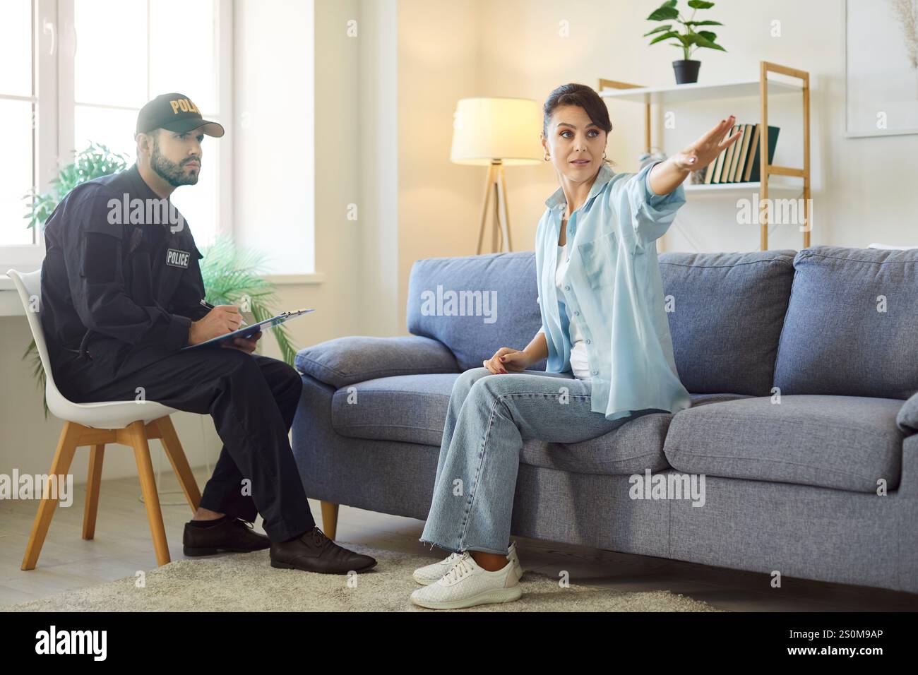 Police officer listening to woman explaining details while taking notes ...
