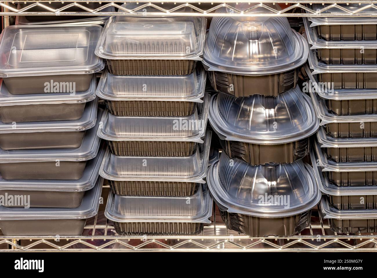 Stacked food containers awaiting distribution in a busy kitchen setting ...