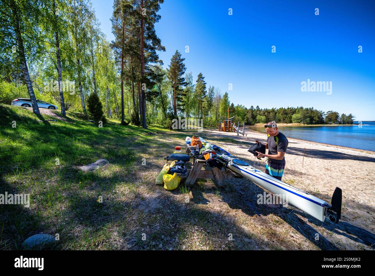 Washing up the kayak at Ölmos beach in Kemiönsaari, Finland Stock Photo ...