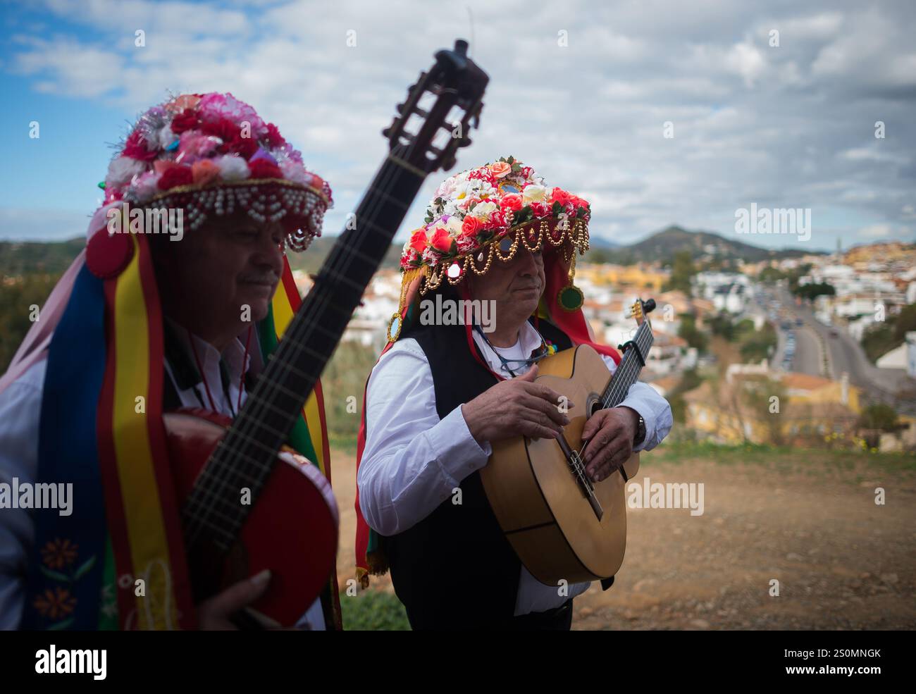 Two persons wearing traditional costumes are seen holding instrument ...