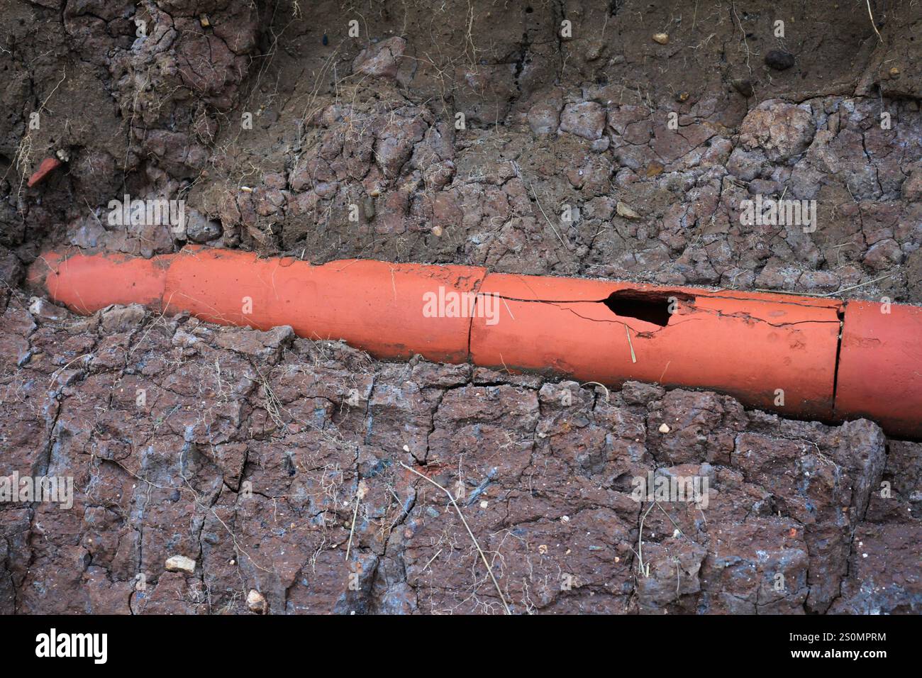 Broken orange clay drainage pipe exposed by coastal erosion at Spurn ...