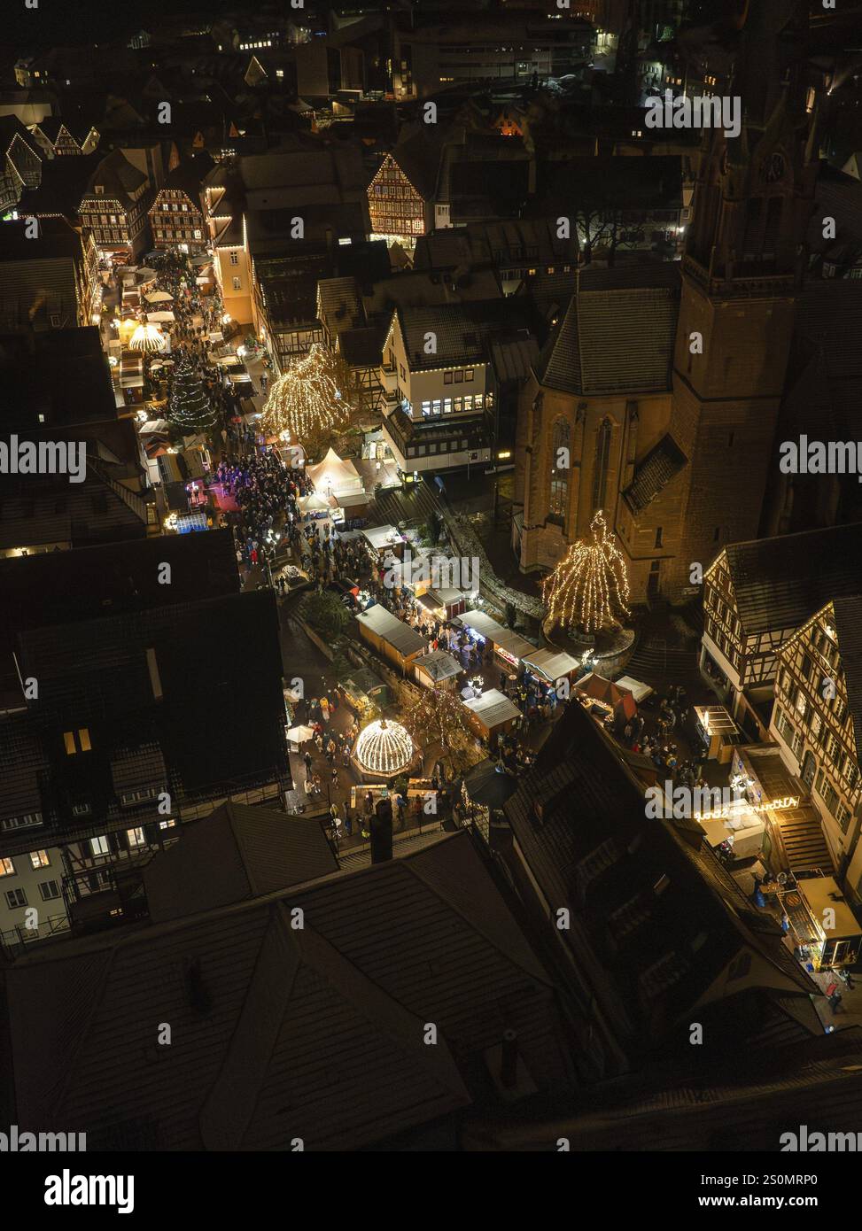 Aerial view of a Christmas market at night with illuminated stalls and ...