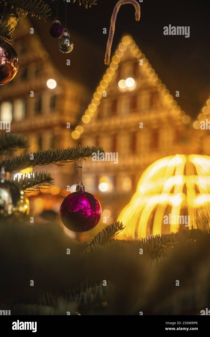 Christmas tree decorated with baubles in front of colourfully ...