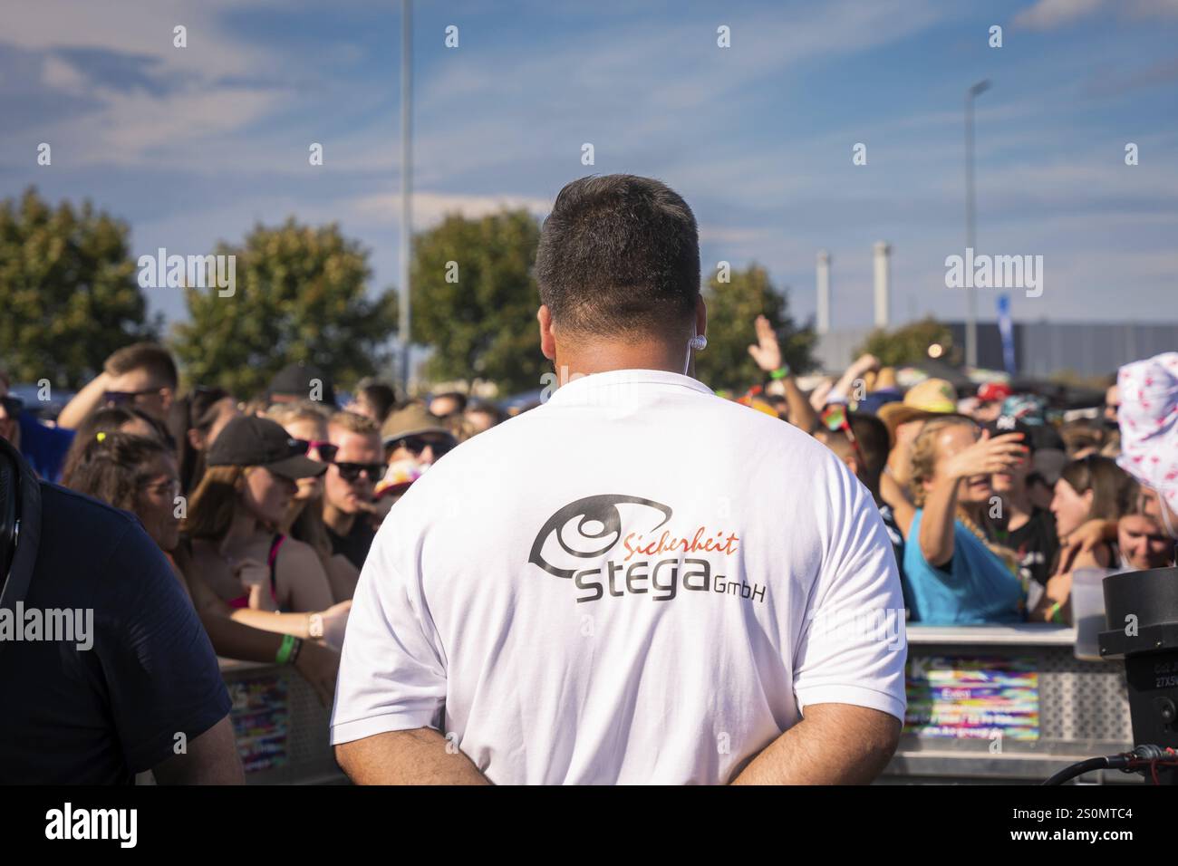 Back view of a security guard with a crowd of people in the background ...