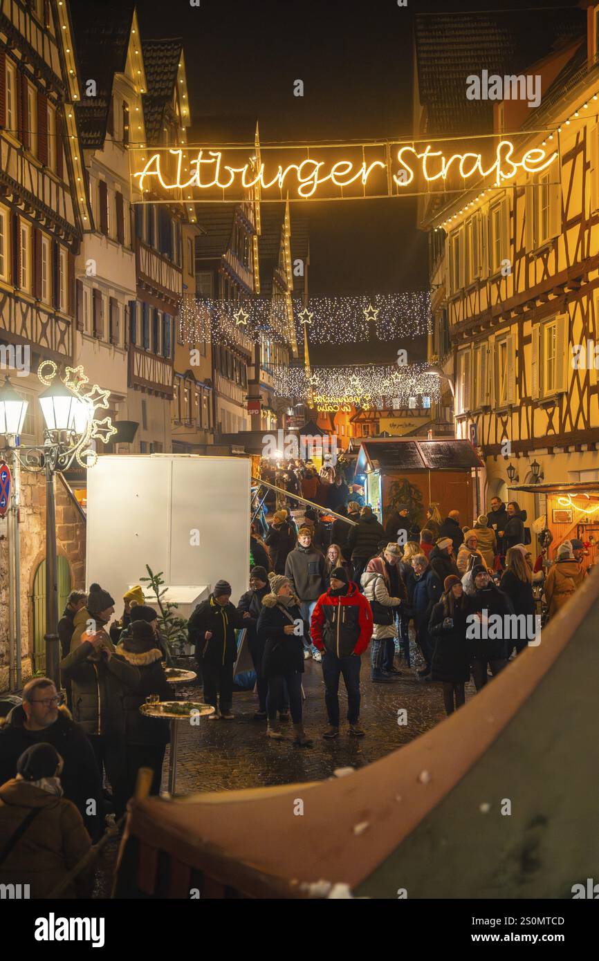 Lively street full of visitors at a Christmas market surrounded by old ...