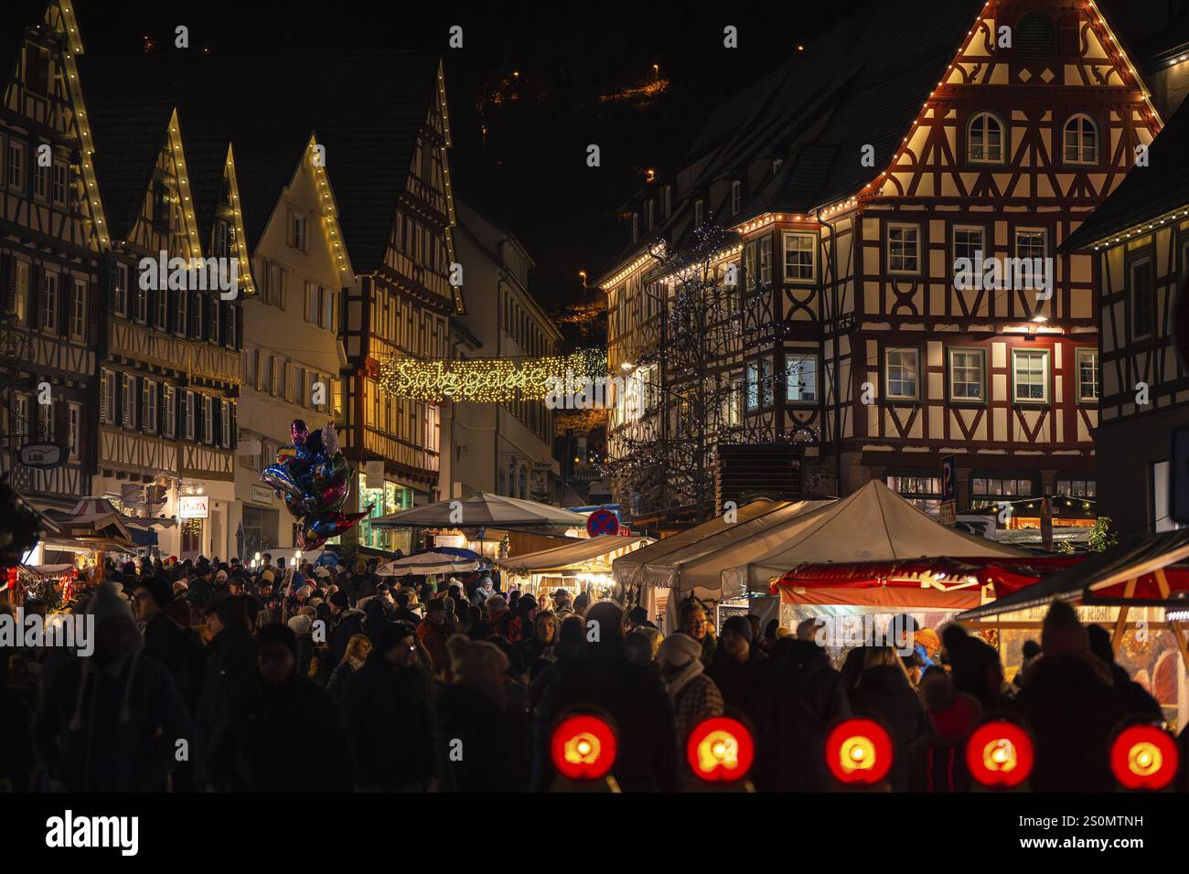 Densely packed crowd at an atmospherically illuminated Christmas market ...