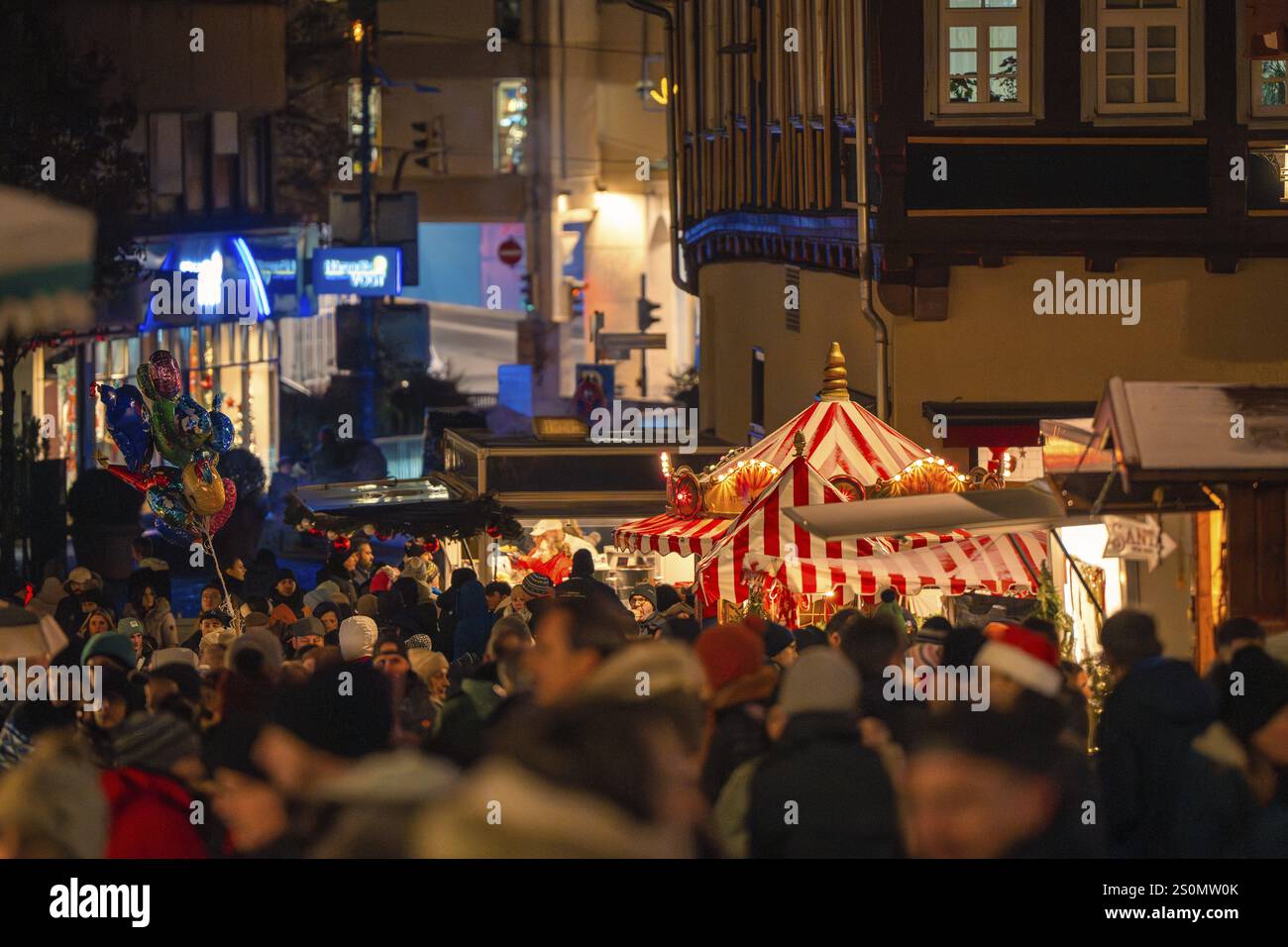 Festive night market with a crowd and illuminated market stalls in the ...