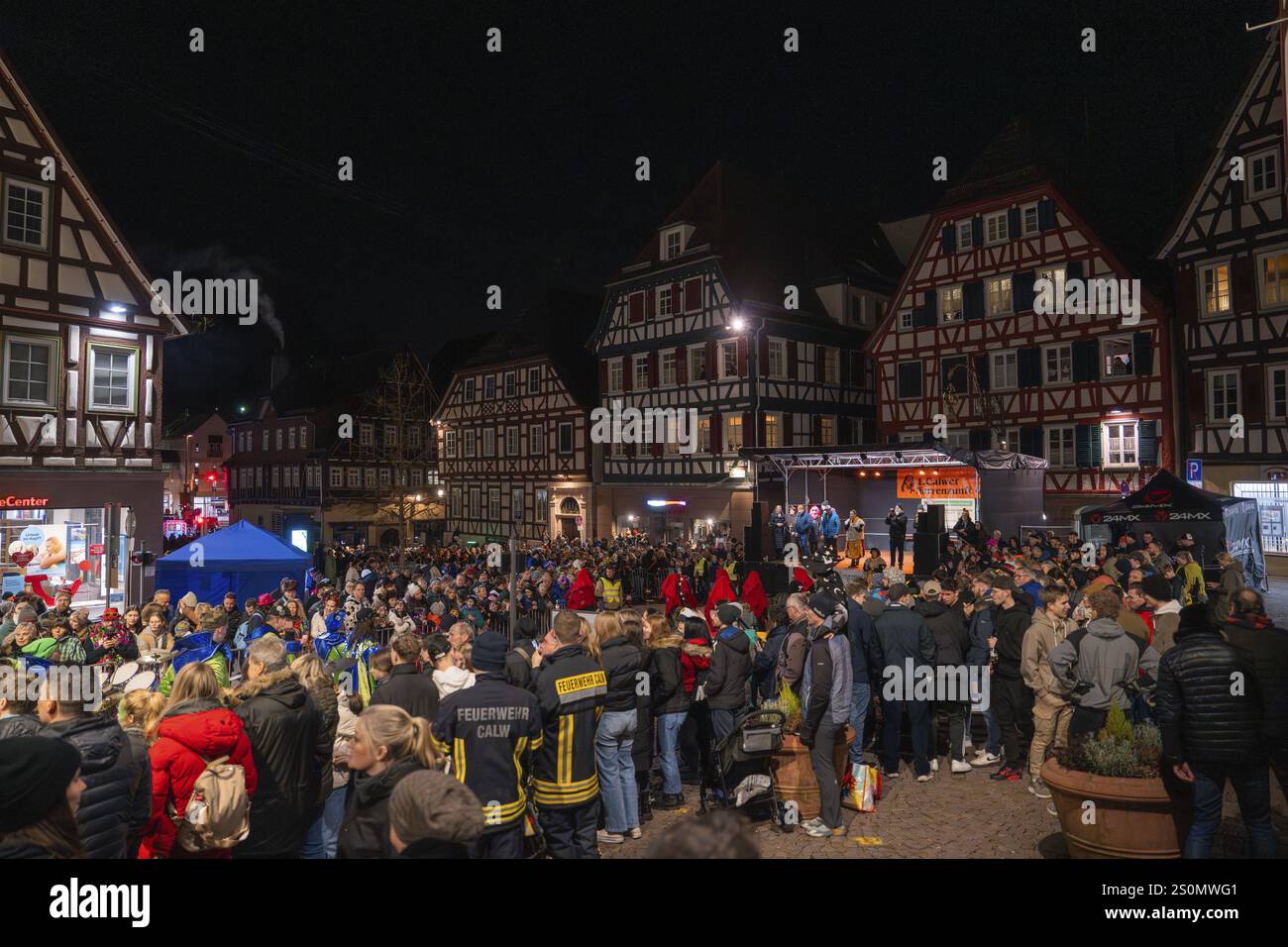 Large crowd gathers at night for a celebration in front of half ...