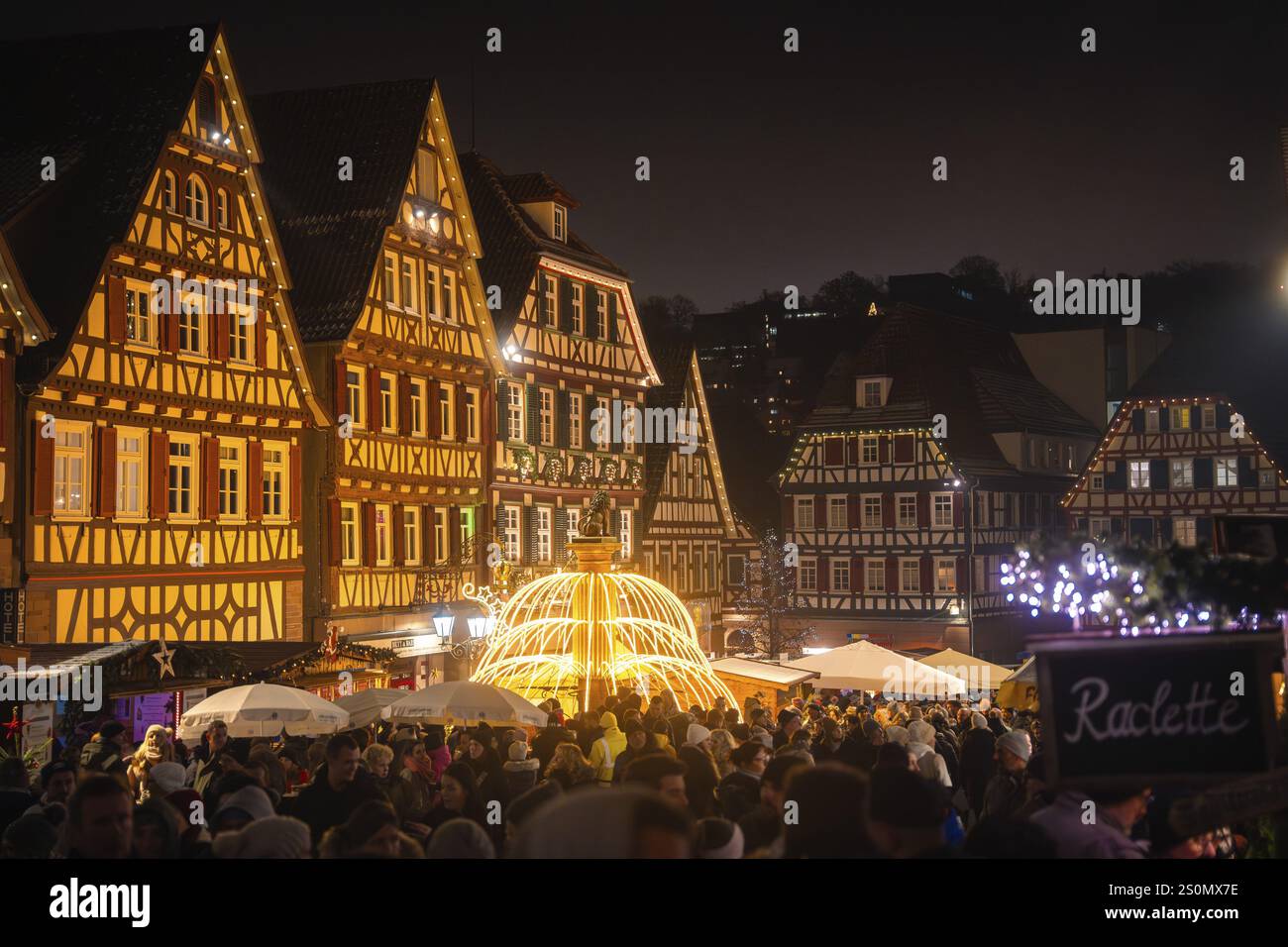 Night shot of a lively Christmas market with shining half-timbered ...