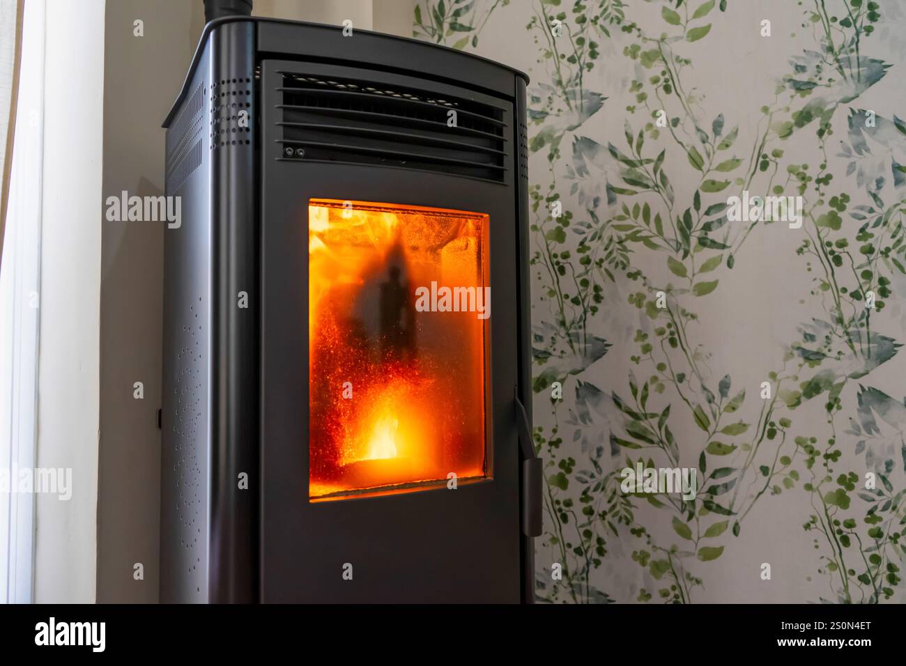 Horizontal photo of a very dirty pellet stove inside a living room of a ...