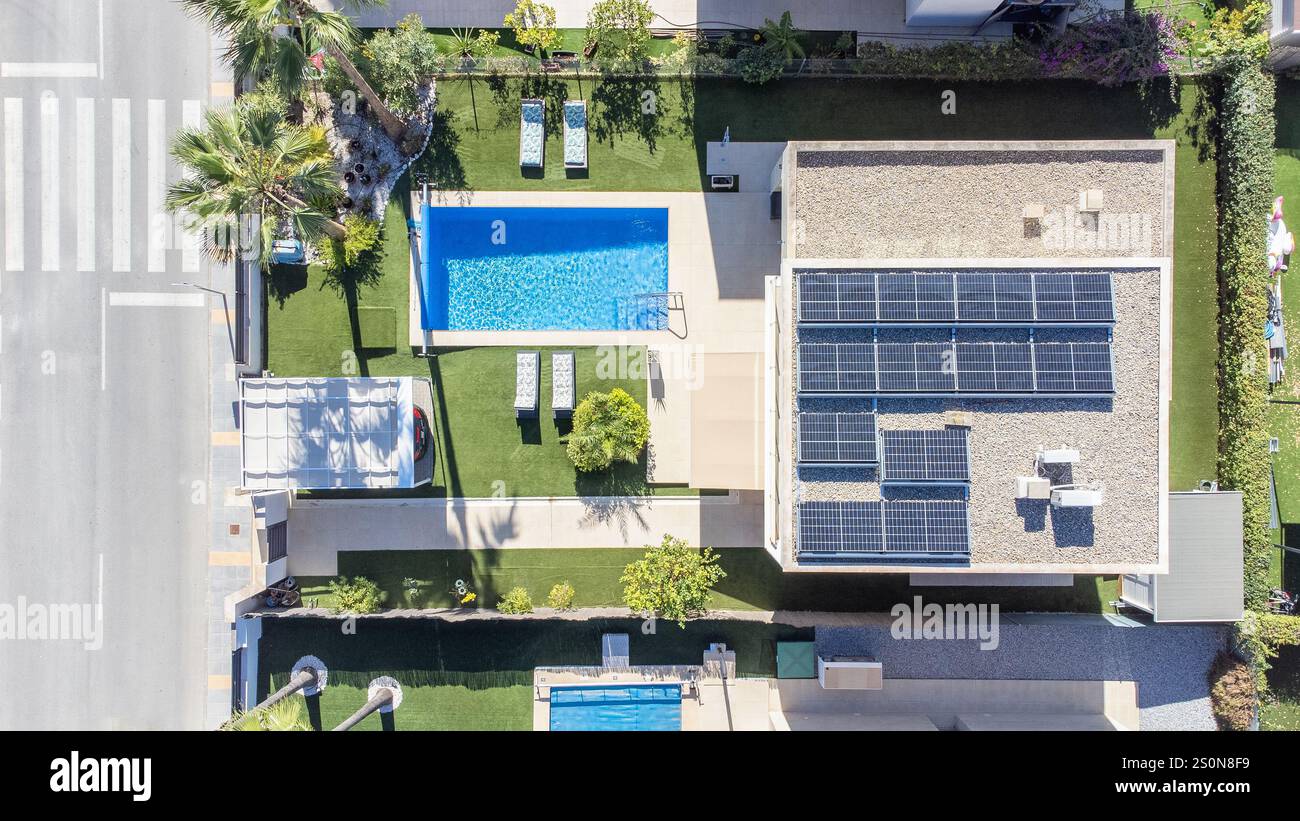 Overhead view of a modern property with solar panels, a swimming pool ...