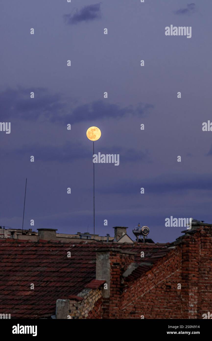 The full moon over the rooftop shines so brightly the moon is aligned ...