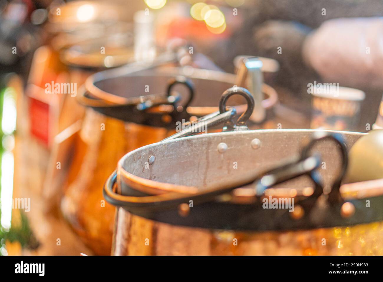 Image of copper-colored cooking pots with lids arranged on a stovetop ...