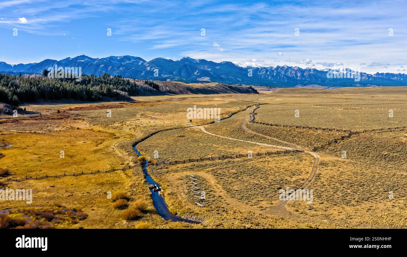 Scenic Mountain Landscape with Meadows, Streams, and Fences Under a ...