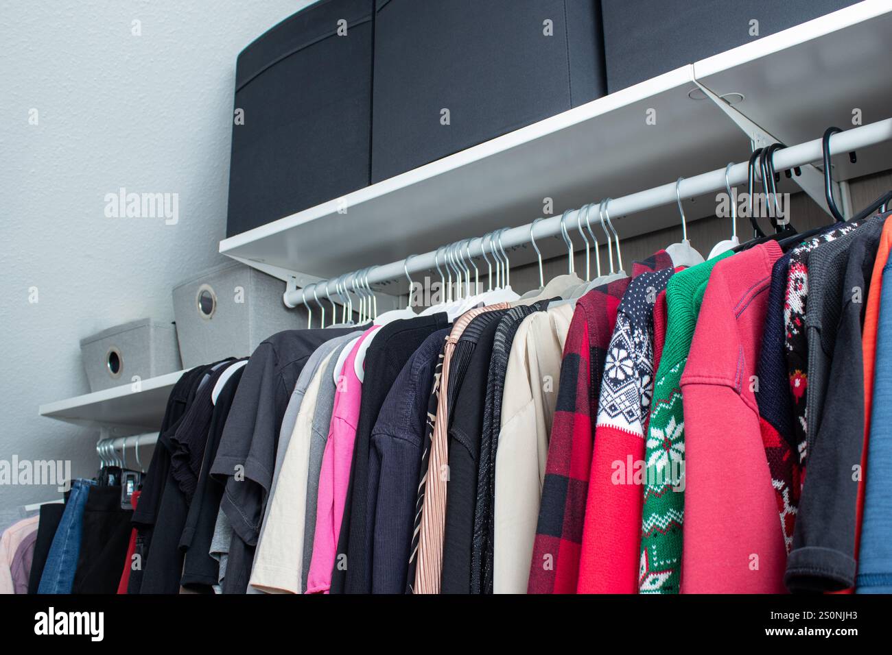 Organized wardrobe with cloths and rack boxes on top Stock Photo - Alamy