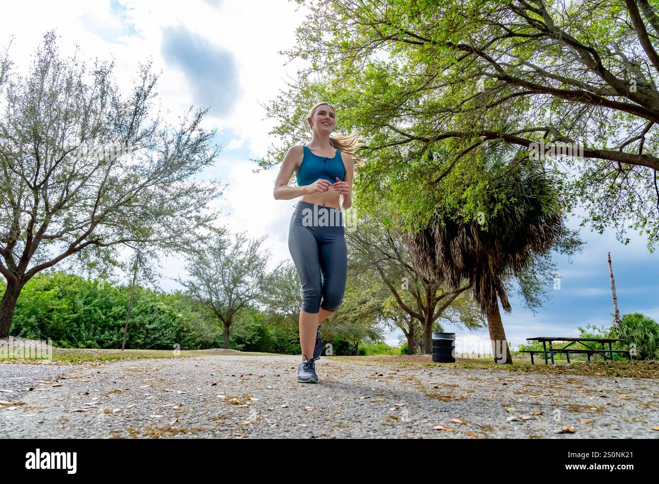 A radiant young woman in sleek, colorful workout gear exercises in a ...