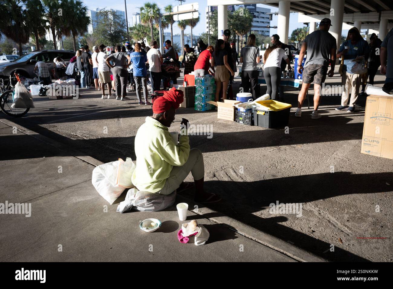 Tampa, Florida, USA. 28th Dec, 2024. A homeless woman eats breakfast as ...