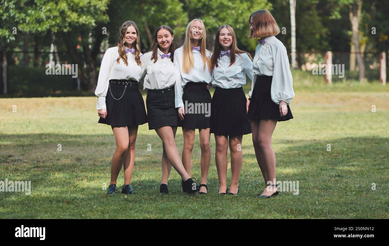 Five high school students in white shirts and bow ties happily reunite ...