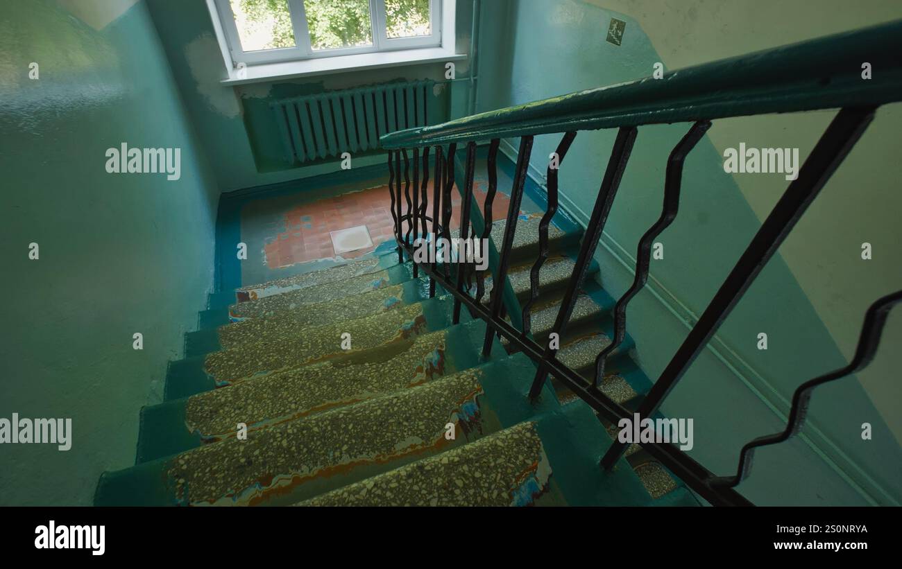 Crumbling staircase with chipped paint and metal railing leading up to ...