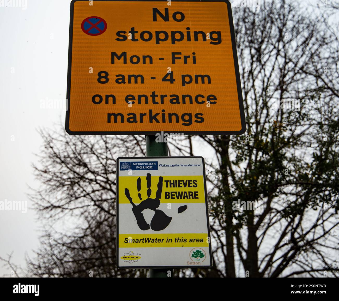 Traffic and security signs on a street warn drivers of no stopping and ...