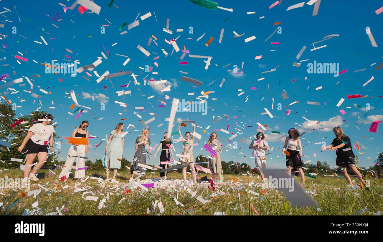 High school graduates joyfully tossing vibrant confetti in the air on a ...
