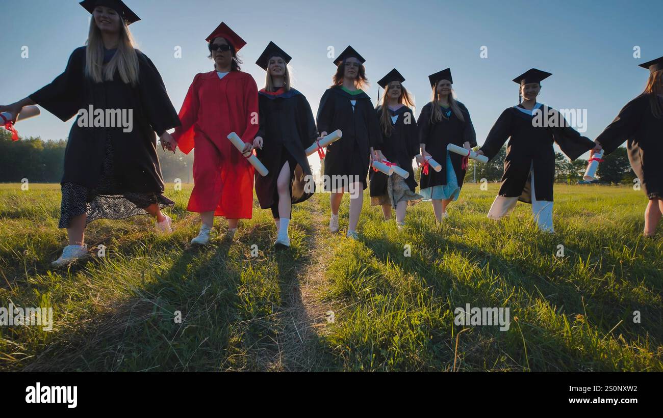 Cheerful graduates celebrating their academic achievement in a field at ...