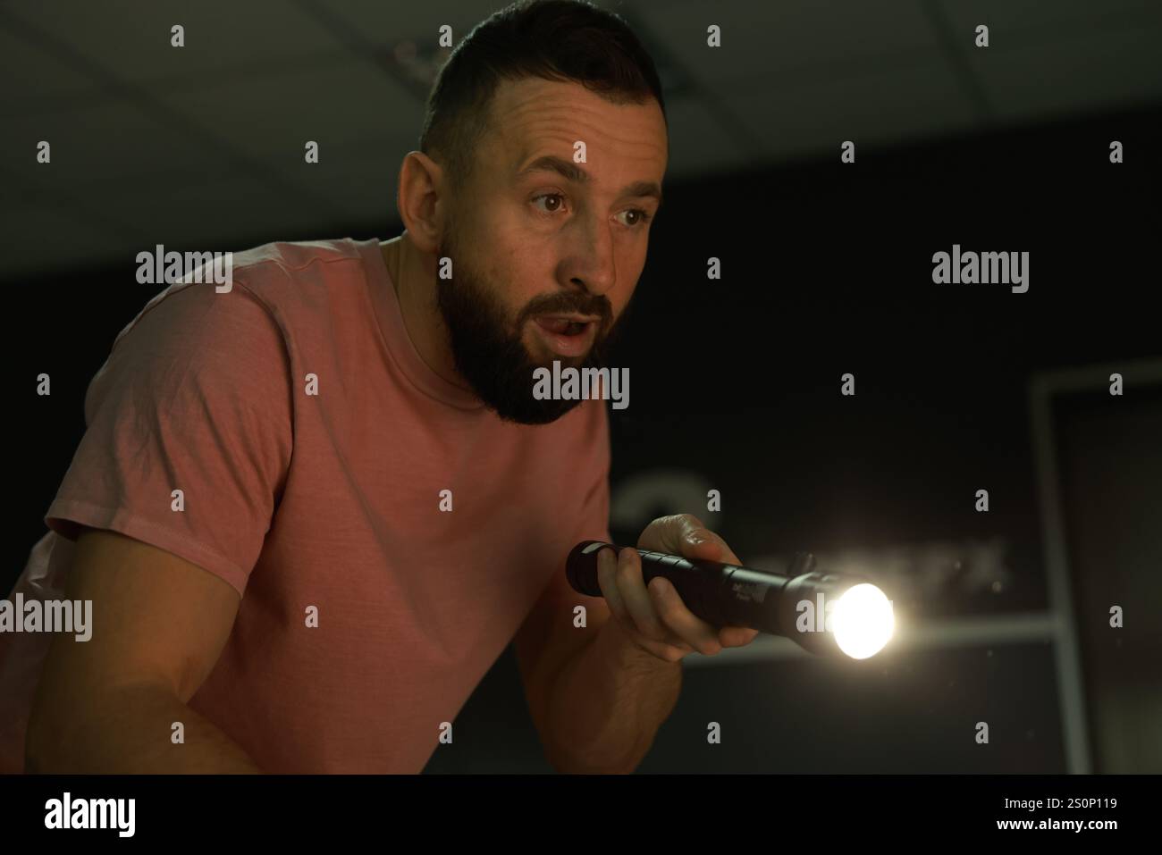Fear of darkness. Scared man with flashlight indoors at night Stock ...