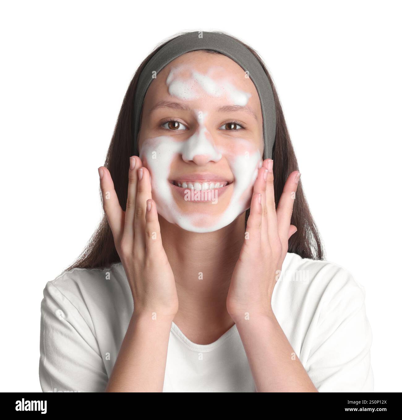 Teenage girl washing her face with cleanser on white background ...