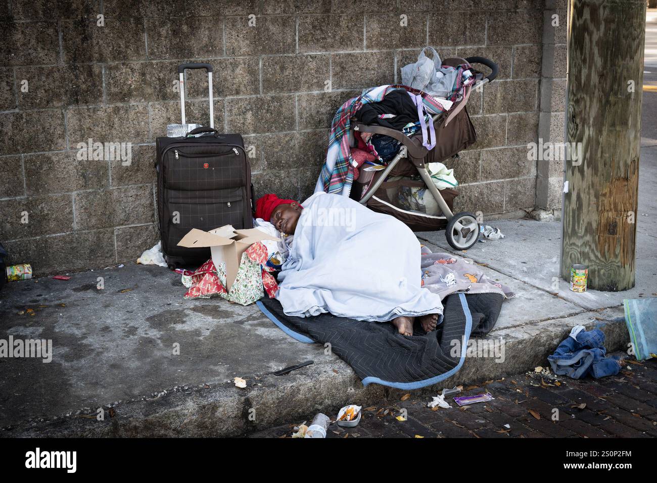 Tampa, Florida, USA. 28th Dec, 2024. A homeless woman tries to sleep on ...