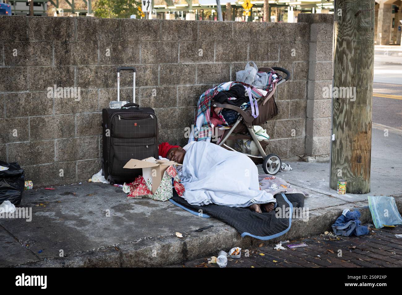 Tampa, Florida, USA. 28th Dec, 2024. A homeless woman tries to sleep on ...