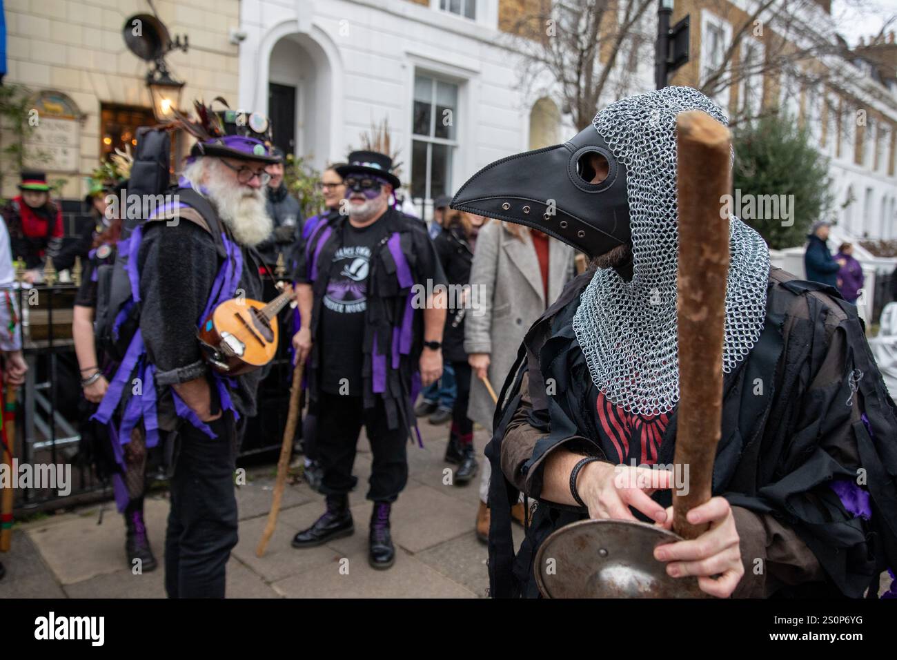London, UK. 28th Dec, 2024. A Morris Dancer wearing a mask stands in ...
