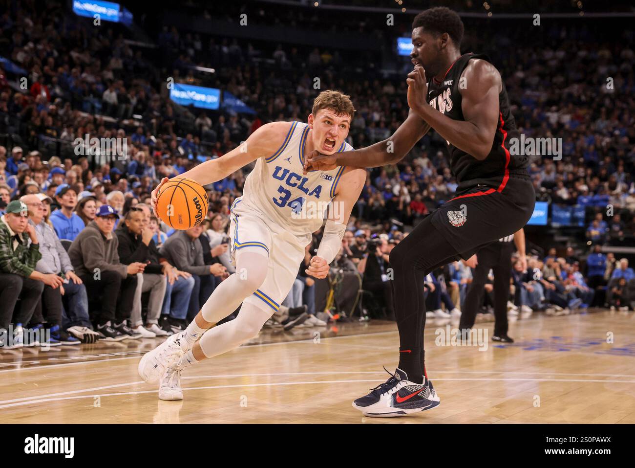 UCLA's Tyler Bilodeau, left, dribbles past Gonzaga's Graham Ike, right ...
