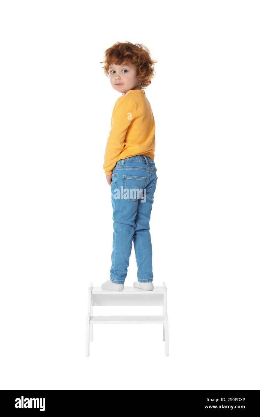 Little boy standing on step stool against white background Stock Photo ...