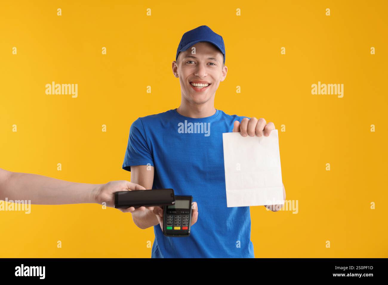 Fast-food worker taking payment from client via terminal on orange ...