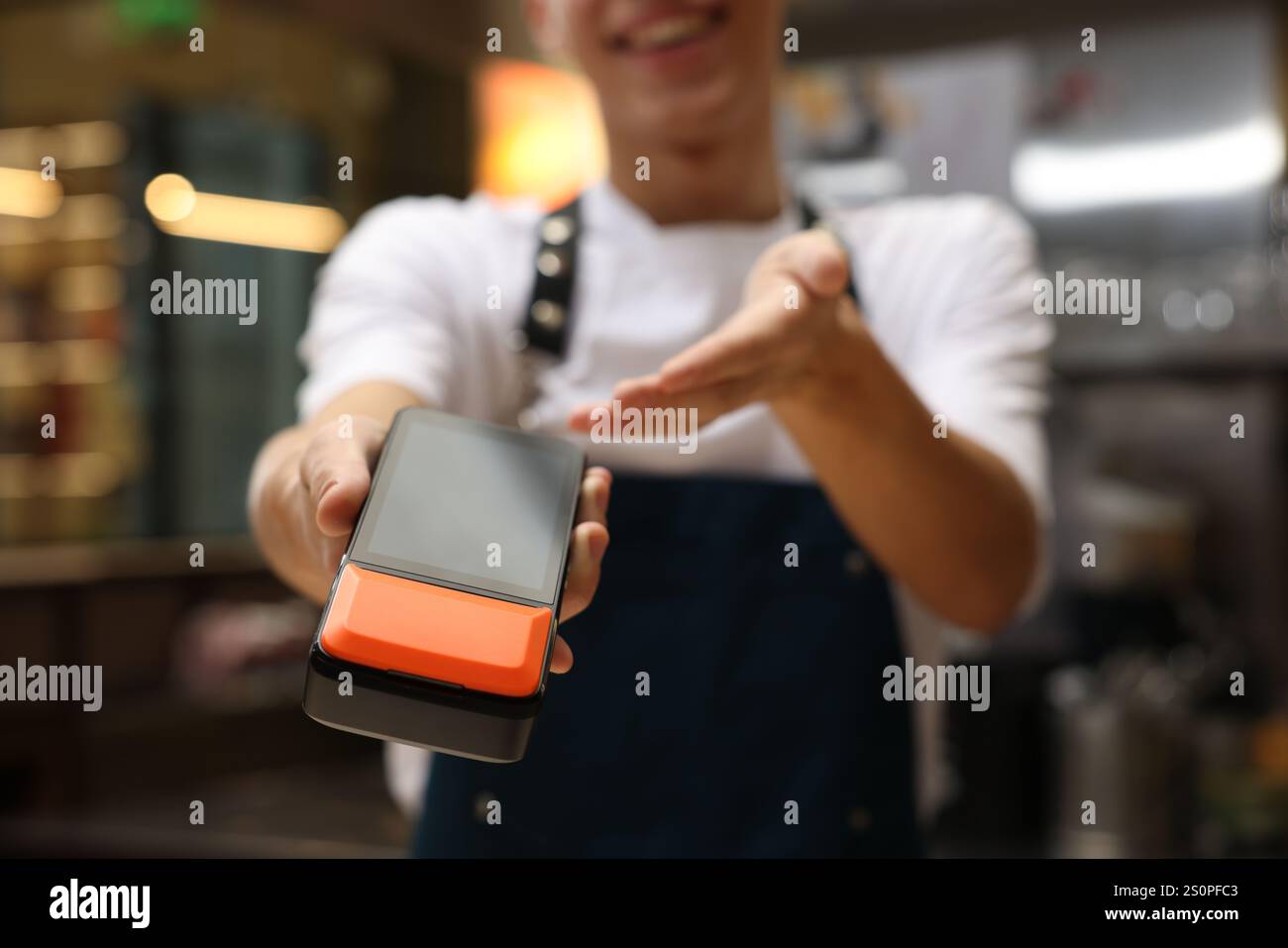 Cafe worker with payment terminal indoors, closeup Stock Photo - Alamy